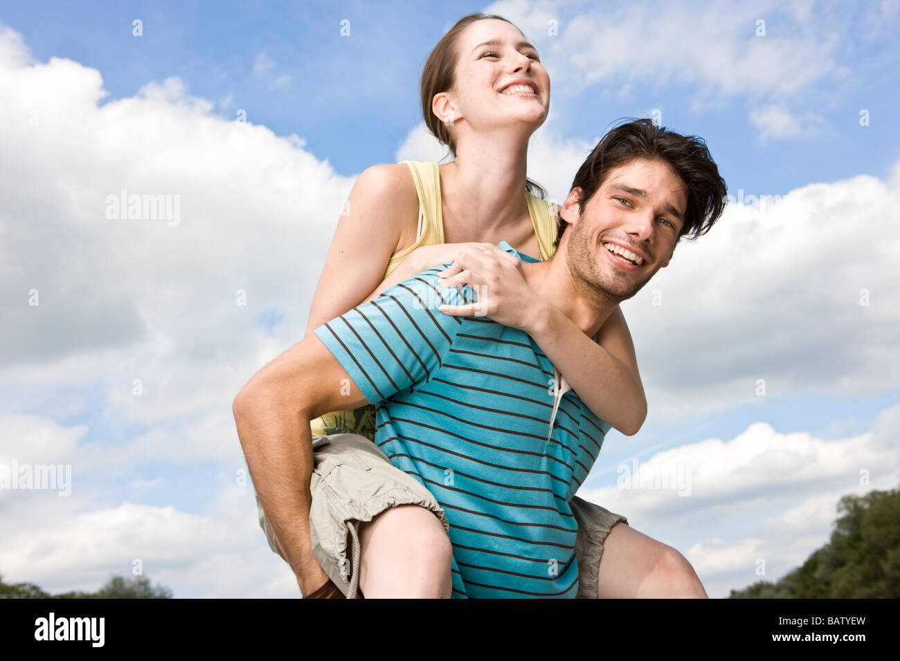 portrait of young man giving girlfriend piggyback ride Stock Photo - Alamy