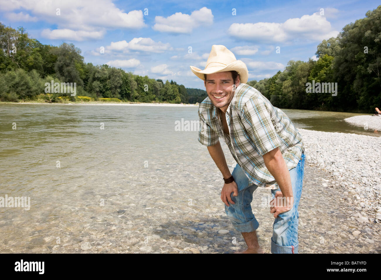 portrait of young man standing in water of river Stock Photo - Alamy
