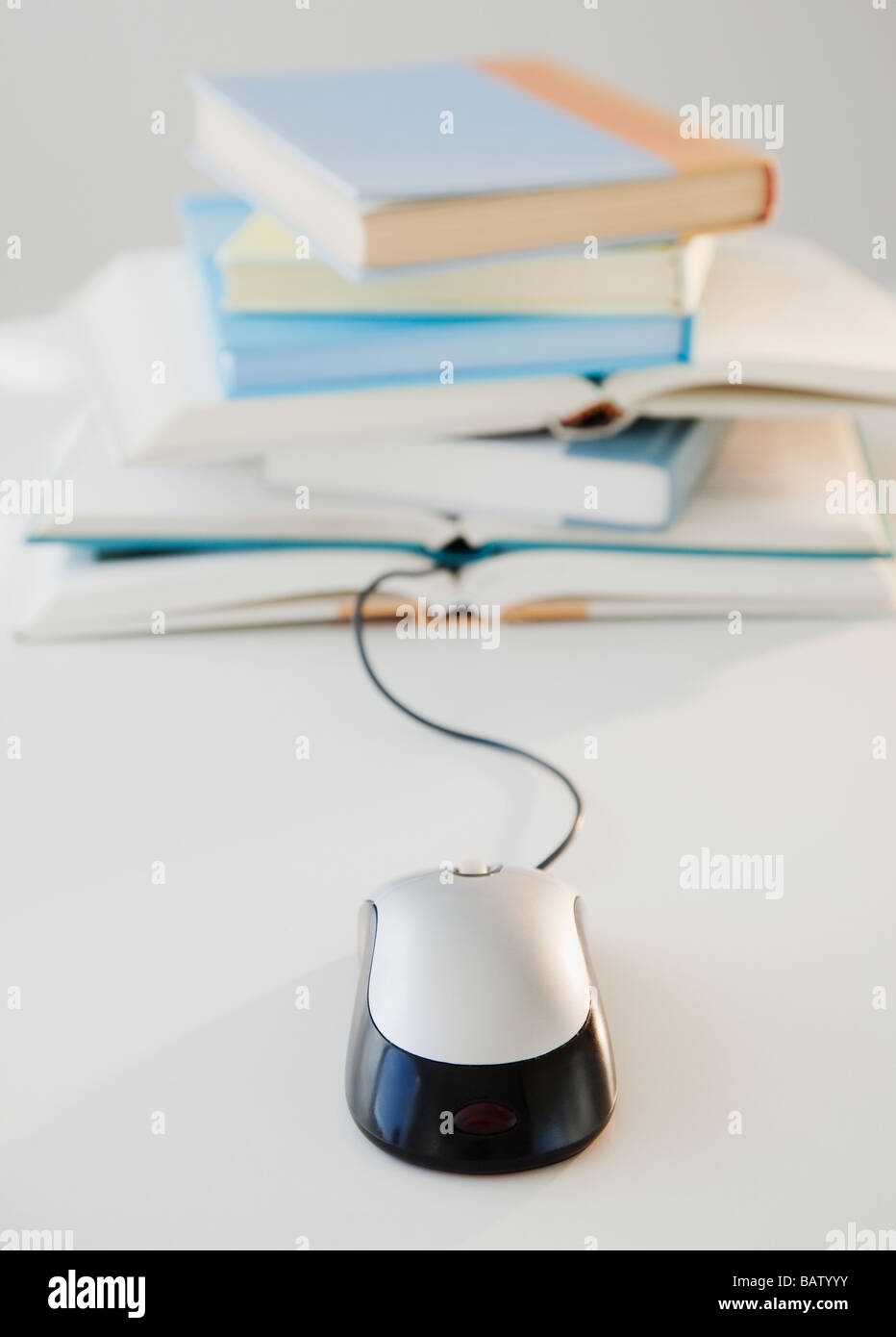 Computer mouse near pile of books, studio shot Stock Photo - Alamy