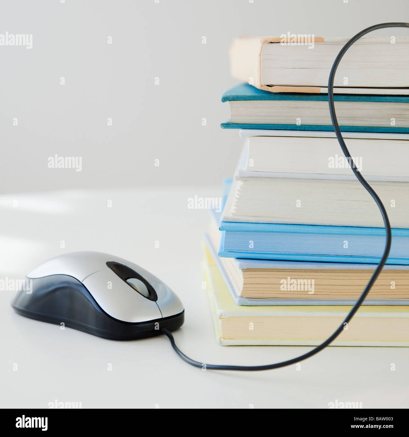 Computer mouse near pile of books, studio shot Stock Photo - Alamy