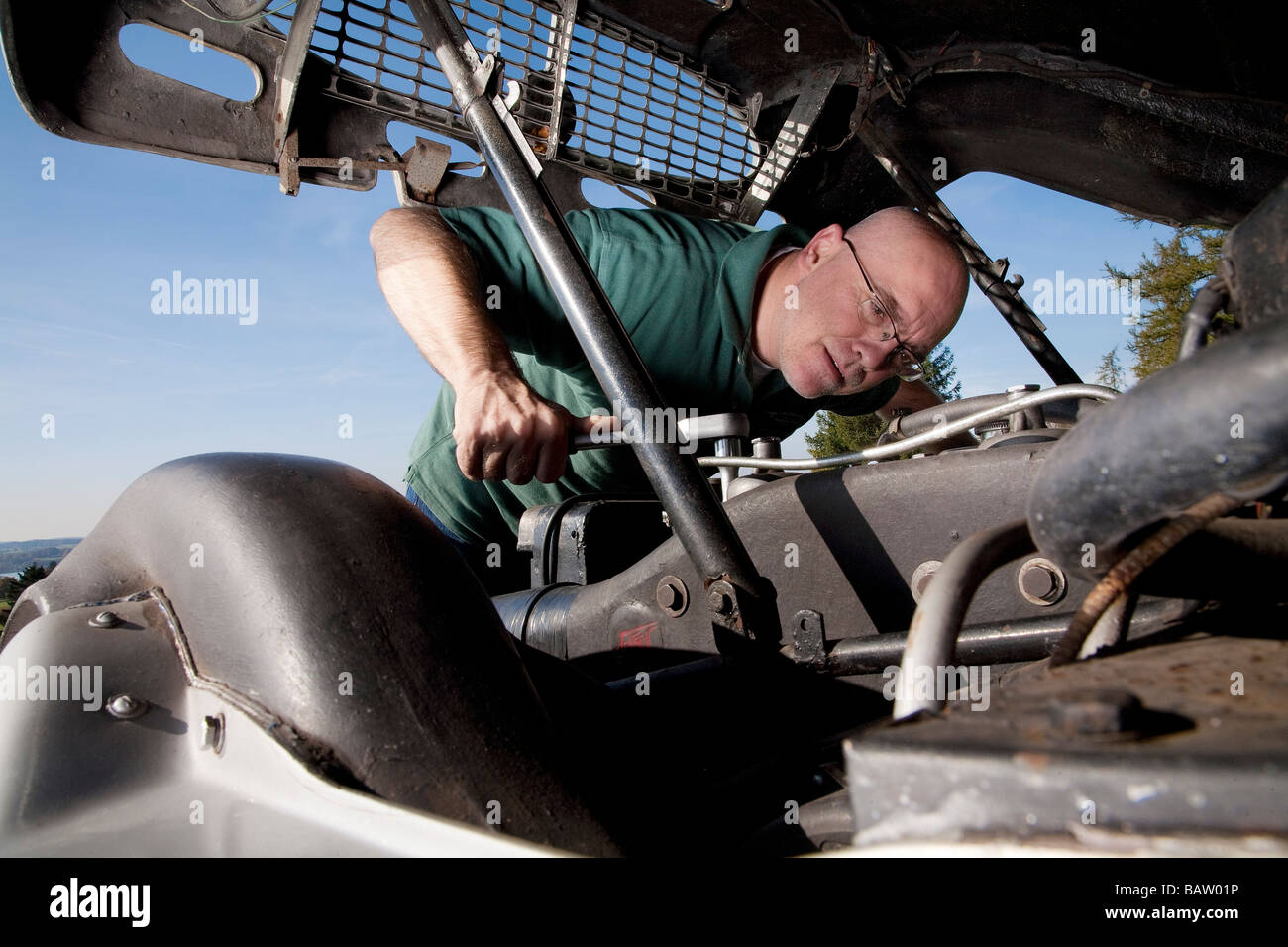 man repairing the engine of his classic car Stock Photo - Alamy