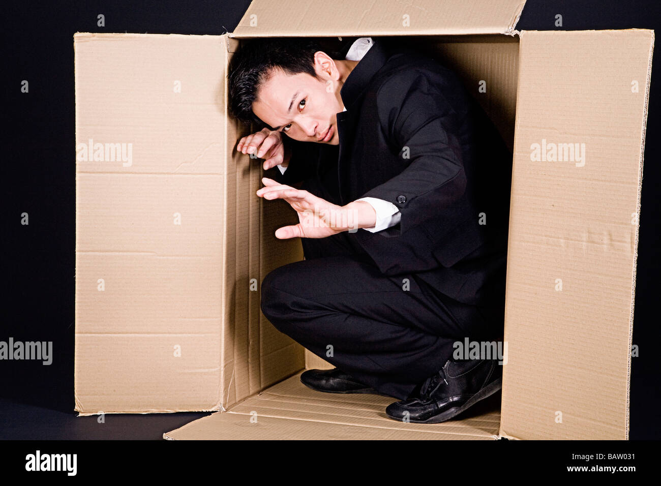 portrait of man hiding in cardboard box Stock Photo - Alamy