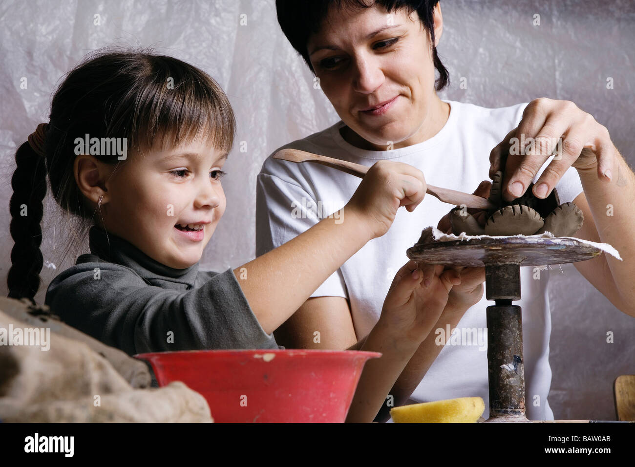 mother and daughter forming sculpture out of clay together Stock Photo ...