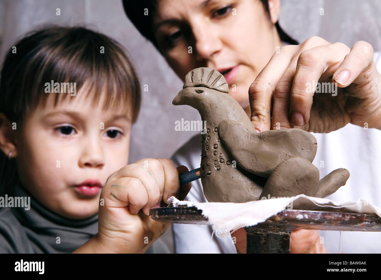 mother and daughter forming sculpture out of clay together Stock Photo ...