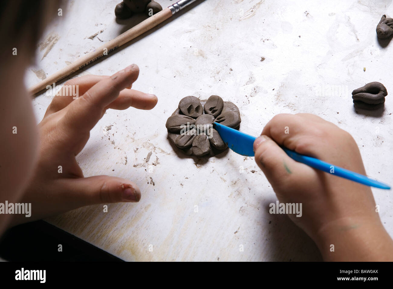 young girl forming flower out of clay Stock Photo - Alamy