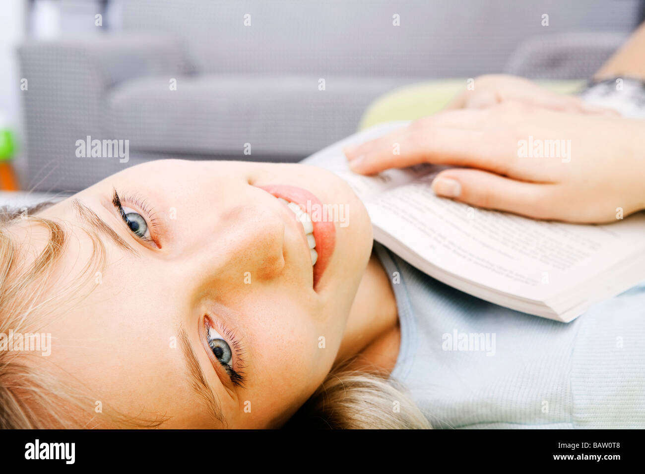portrait of young woman lying on back with book Stock Photo - Alamy
