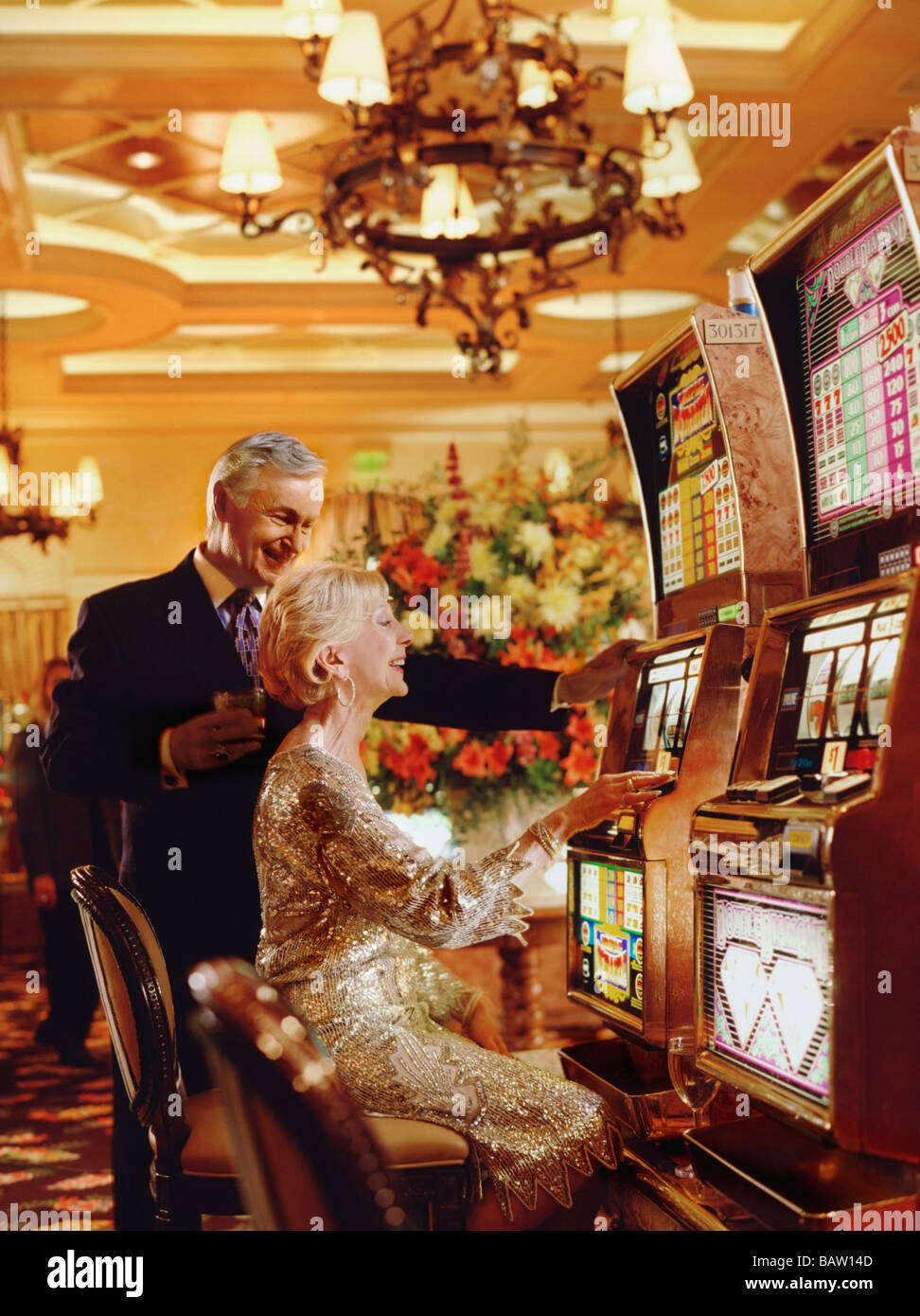 USA, Nevada, Las Vegas, Senior couple in casino playing on slot ...