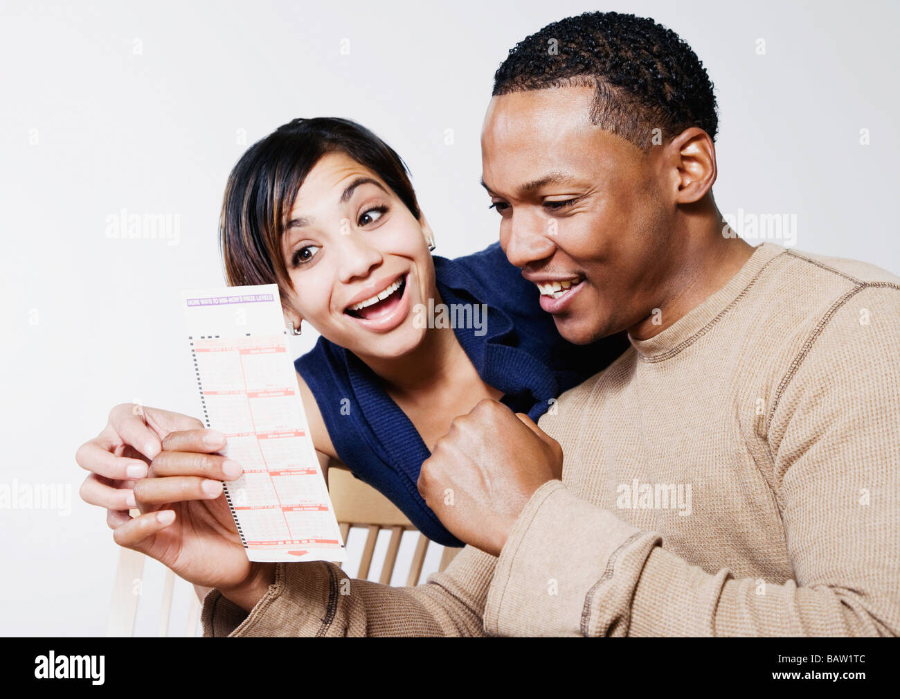 Excited couple looking at lottery ticket Stock Photo - Alamy