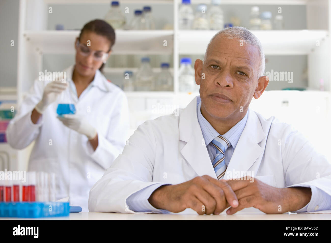African scientist in laboratory with co-worker in background Stock ...
