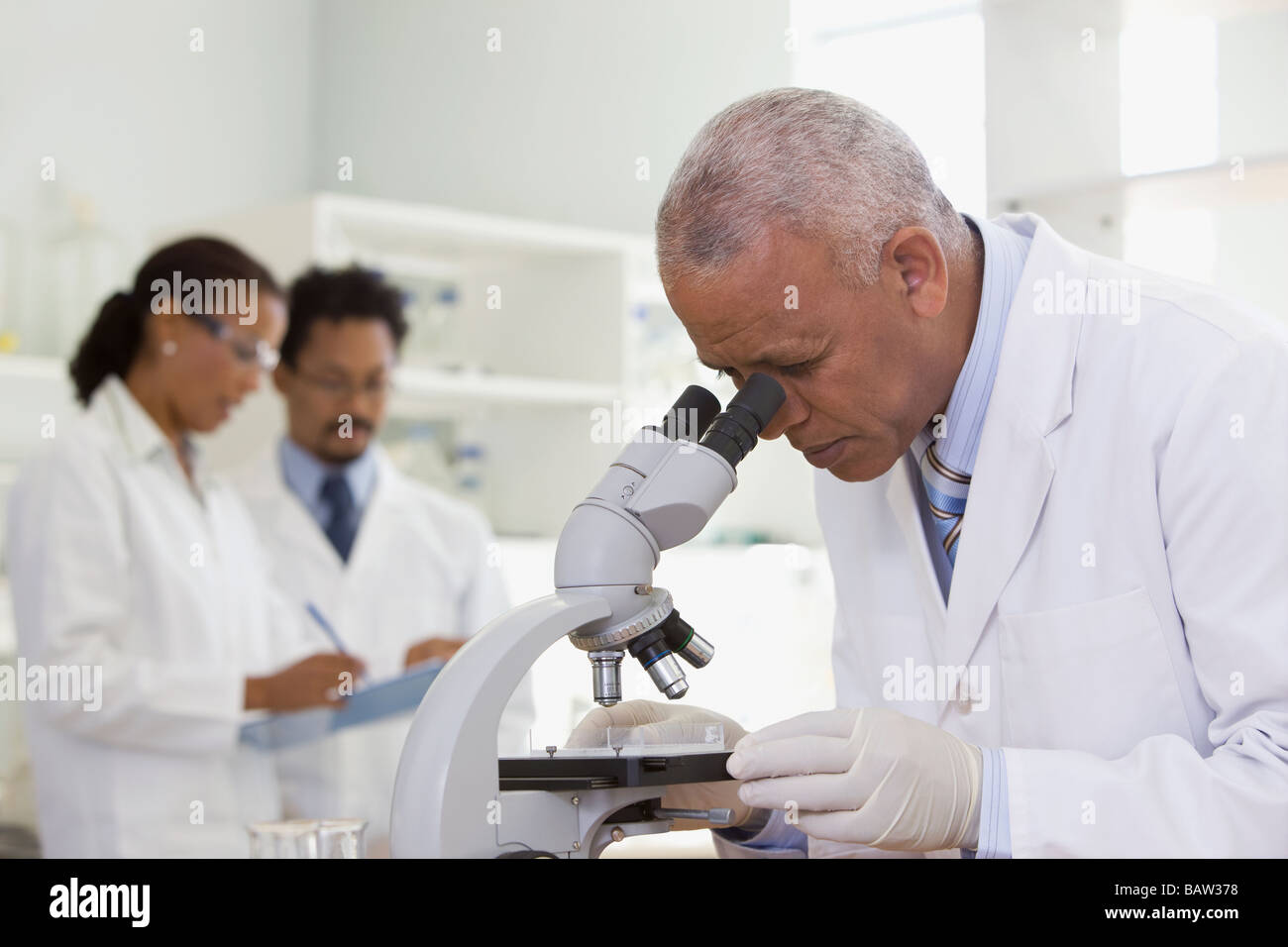 African scientist performing analysis in laboratory with microscope ...