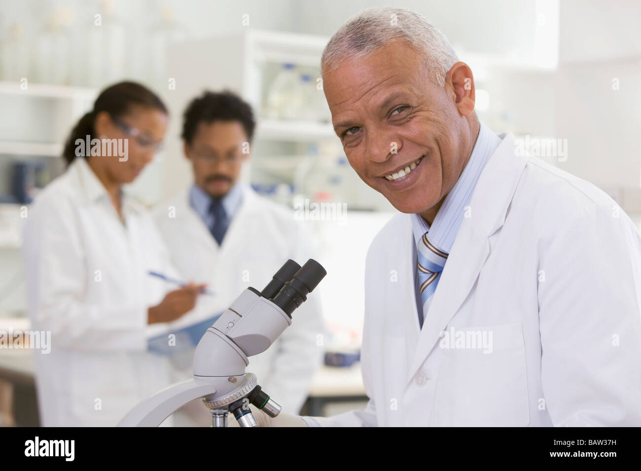 African scientist performing analysis in laboratory with microscope ...