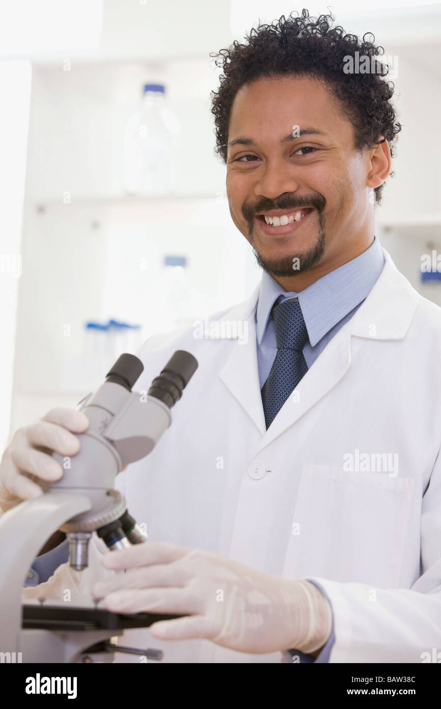 African scientist performing analysis in laboratory with microscope ...