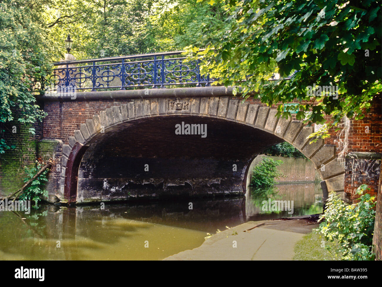 A Victorian brick stone and iron bridge over the Regents Canal at ...