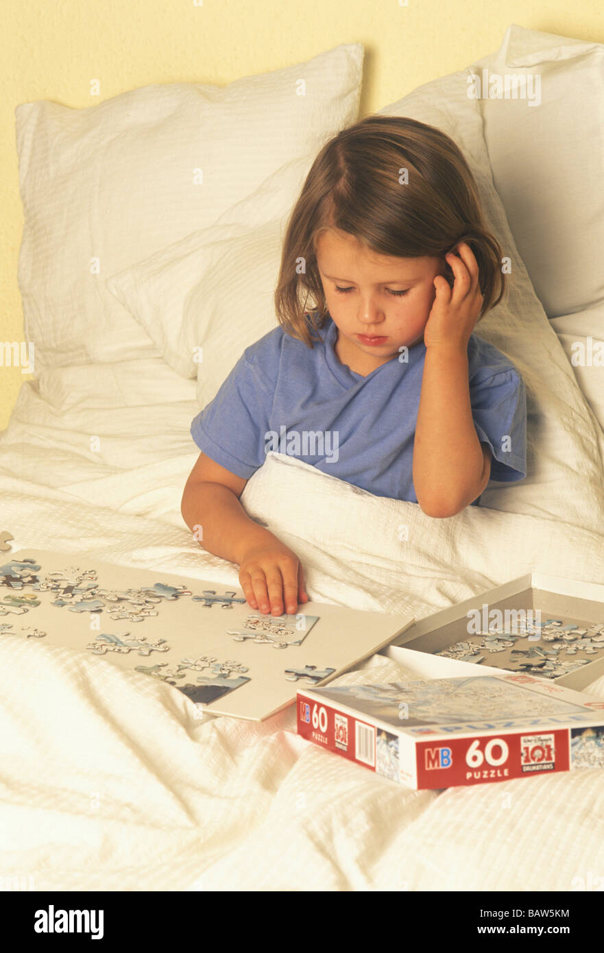 Child doing jigsaw puzzle sitting hi-res stock photography and images ...
