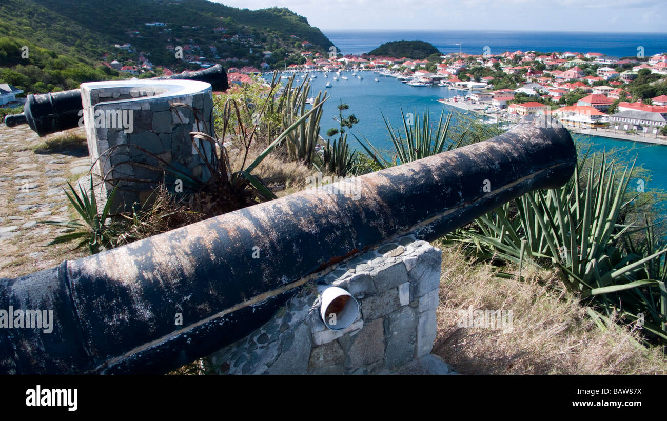 Replica cannon at Fort Gustave above red tin roof buildings in port ...