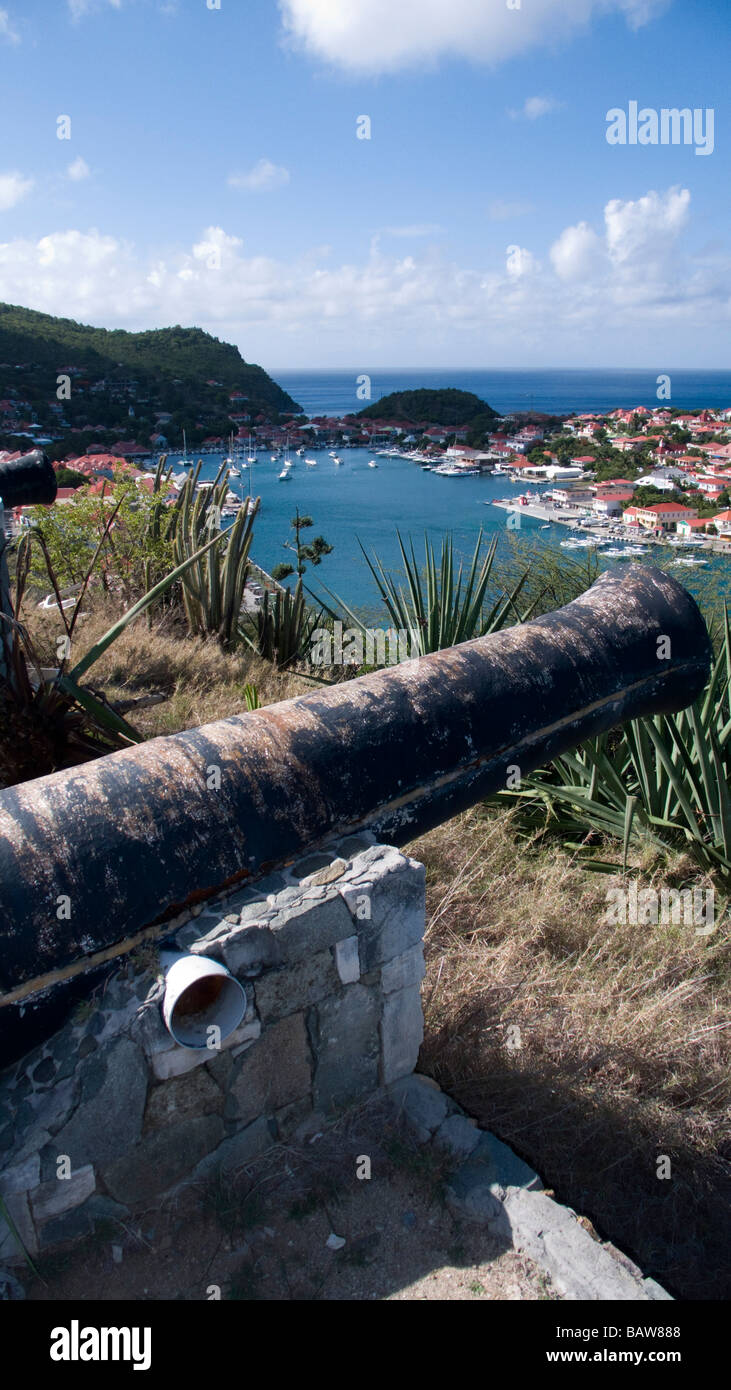 Replica cannon at Fort Gustave above red tin roof buildings in port ...