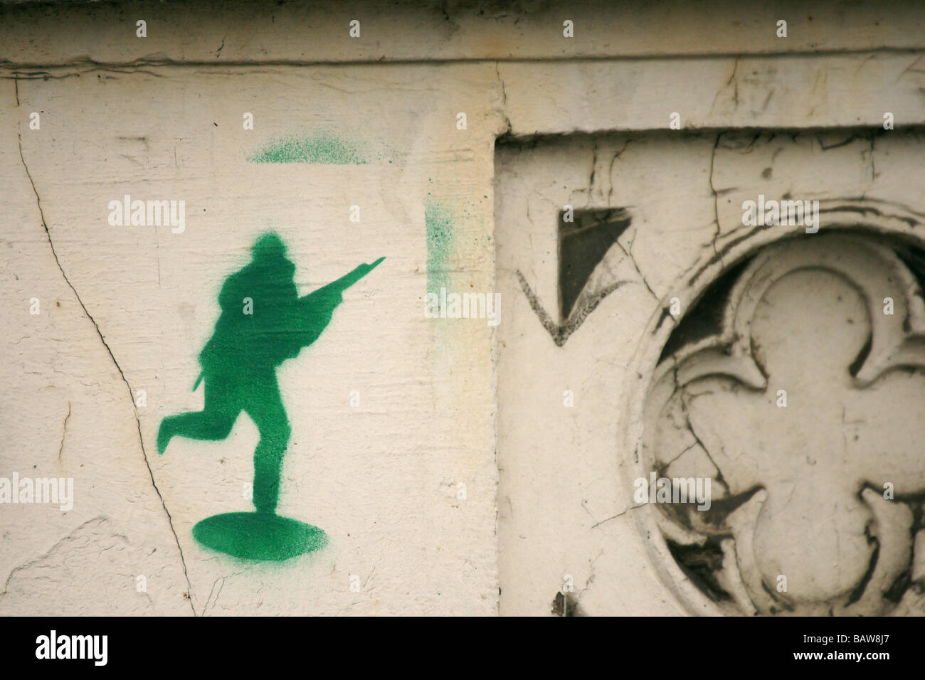 Green sprayed soldier painting on wall running Stock Photo - Alamy