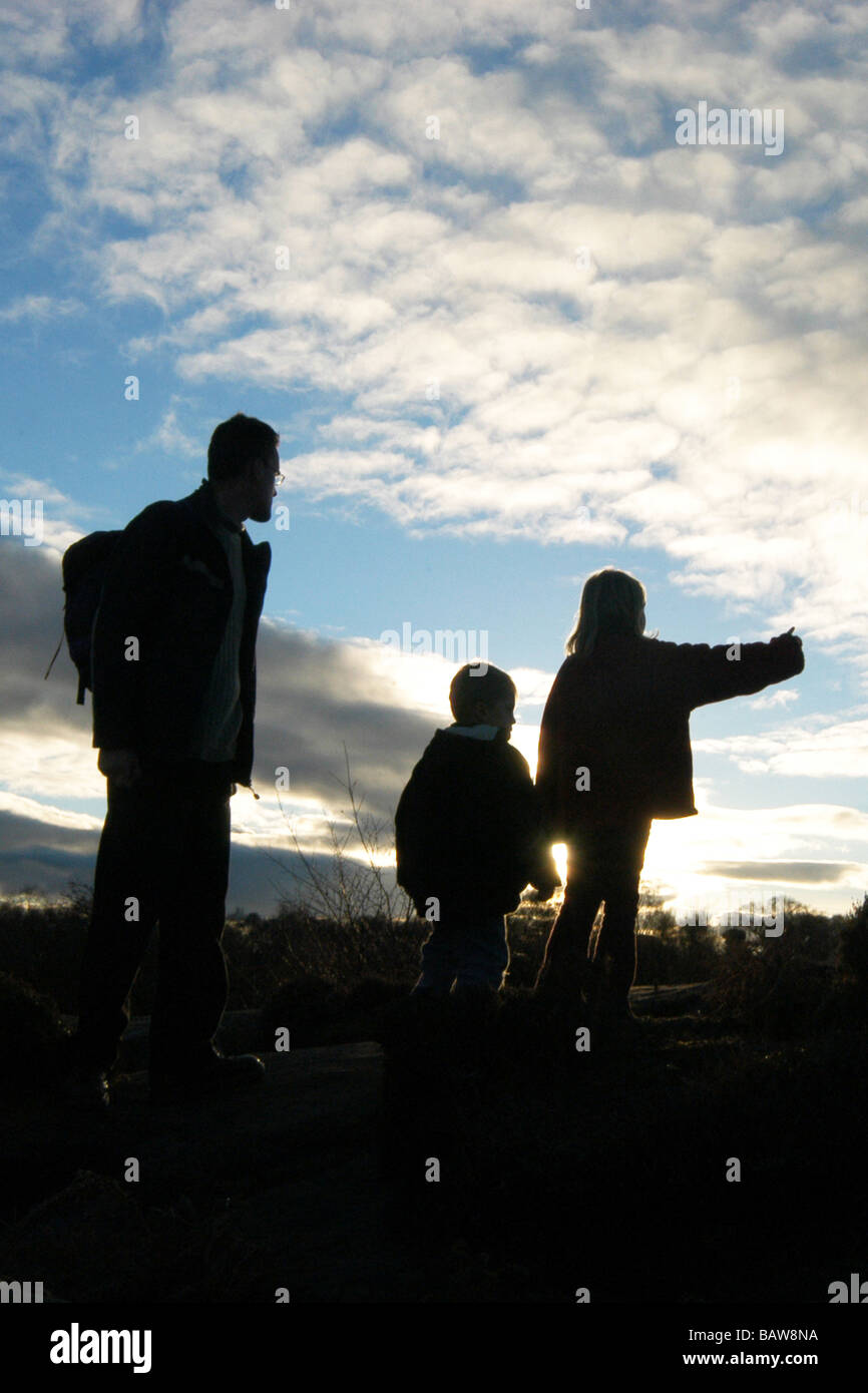 A father and children look out over the sunset on a walk, North ...