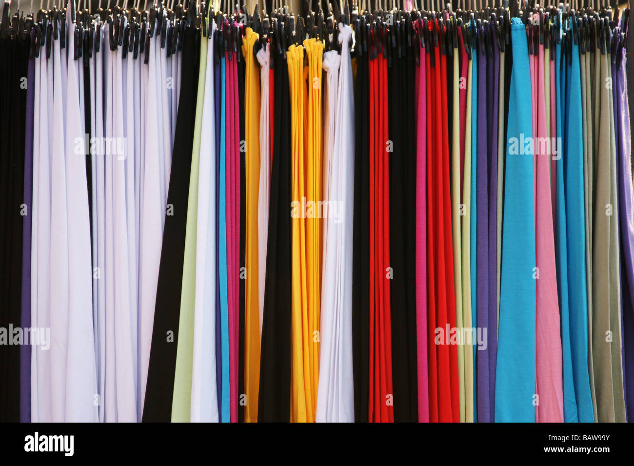 Colourful clothes hanging on rack in market booth stall Stock Photo - Alamy