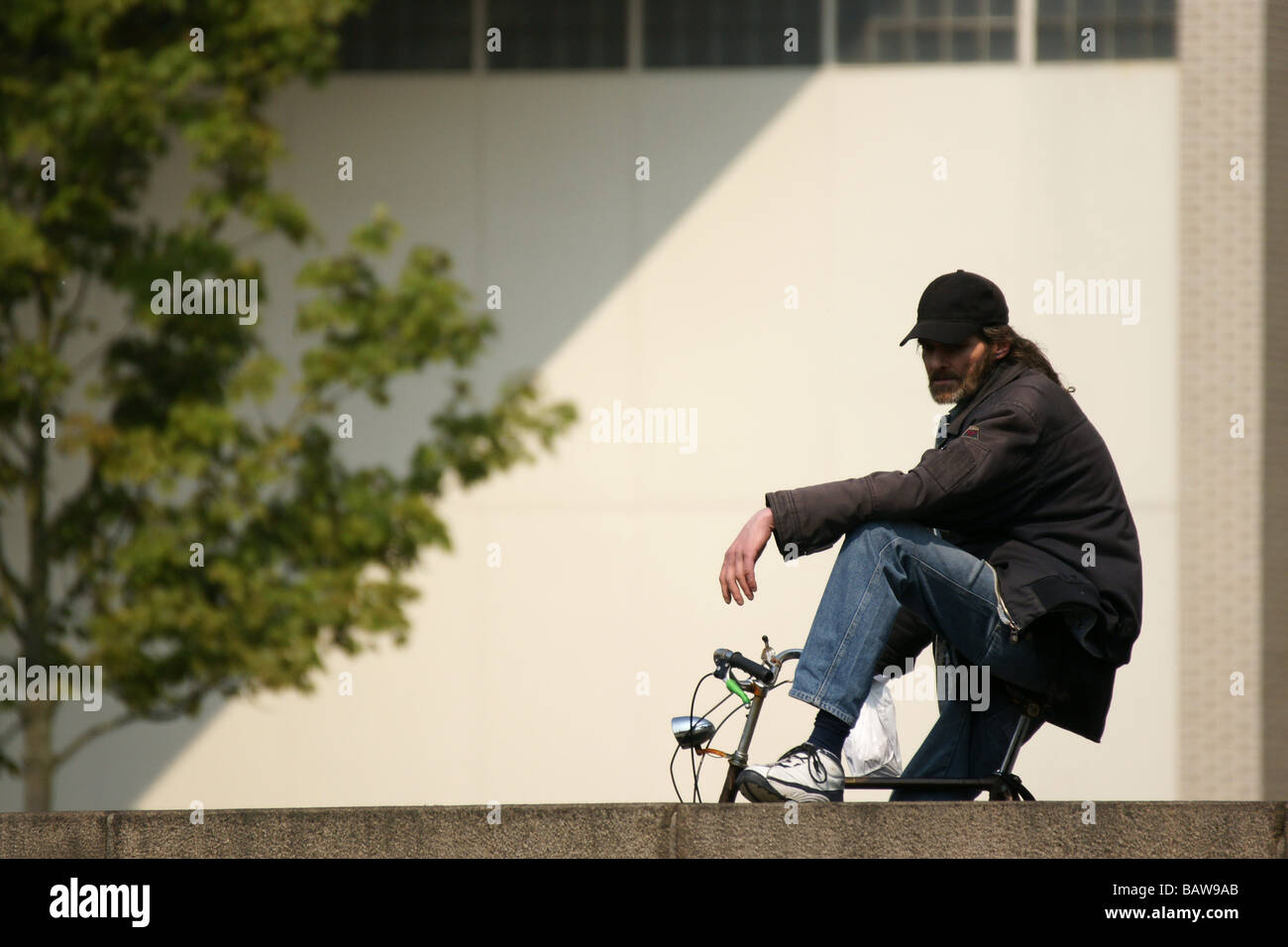 Homeless man sitting on a bicycle alone thinking pondering, Netherlands ...