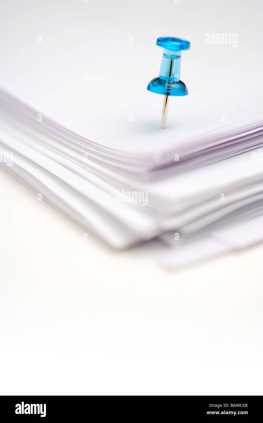 Stack of paper pierced by a drawing pin Stock Photo - Alamy