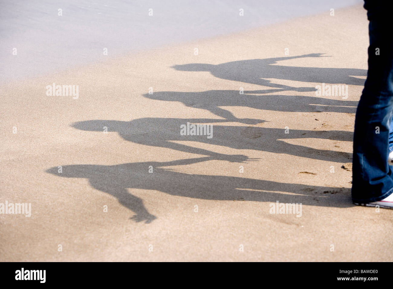 Shadows of friends holding hands on beach Stock Photo - Alamy