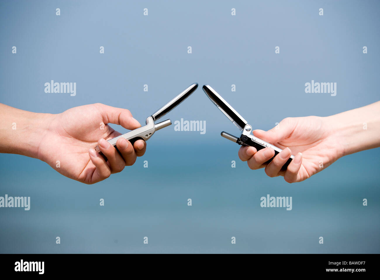 Two hands holding mobile phones Stock Photo - Alamy