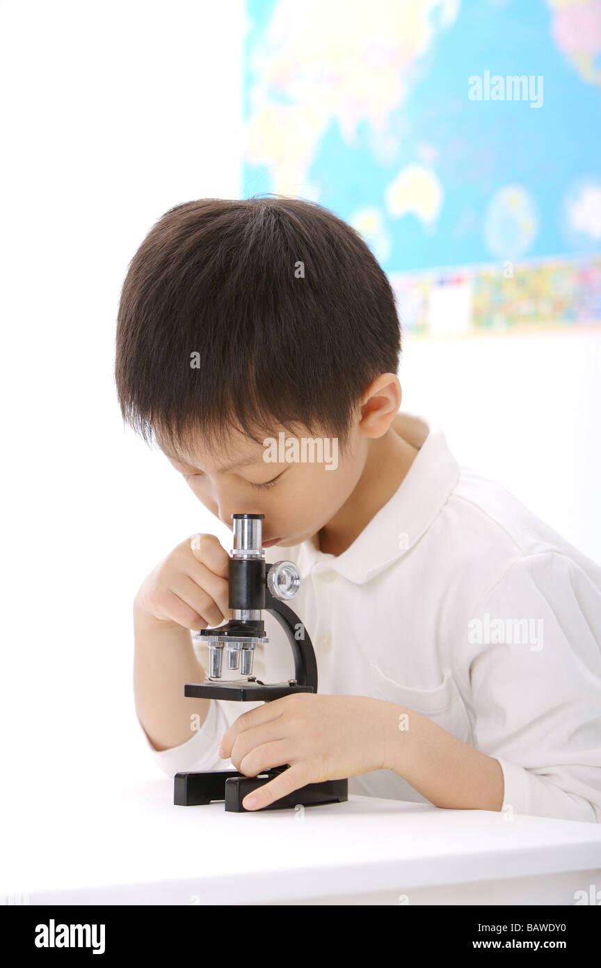 Boy looking through microscope Stock Photo - Alamy