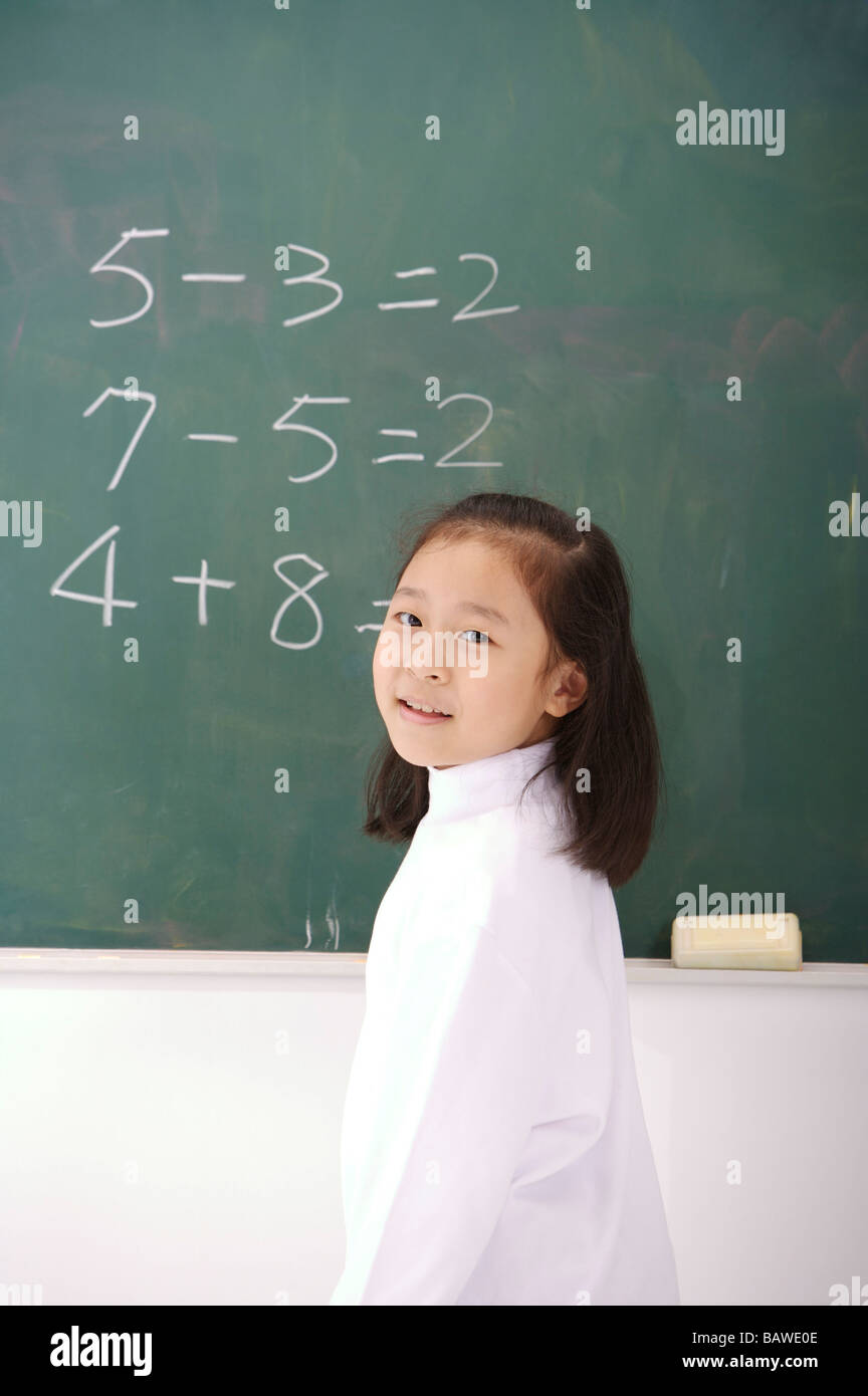 Girl solving mathematical equation on blackboard side view Stock Photo ...