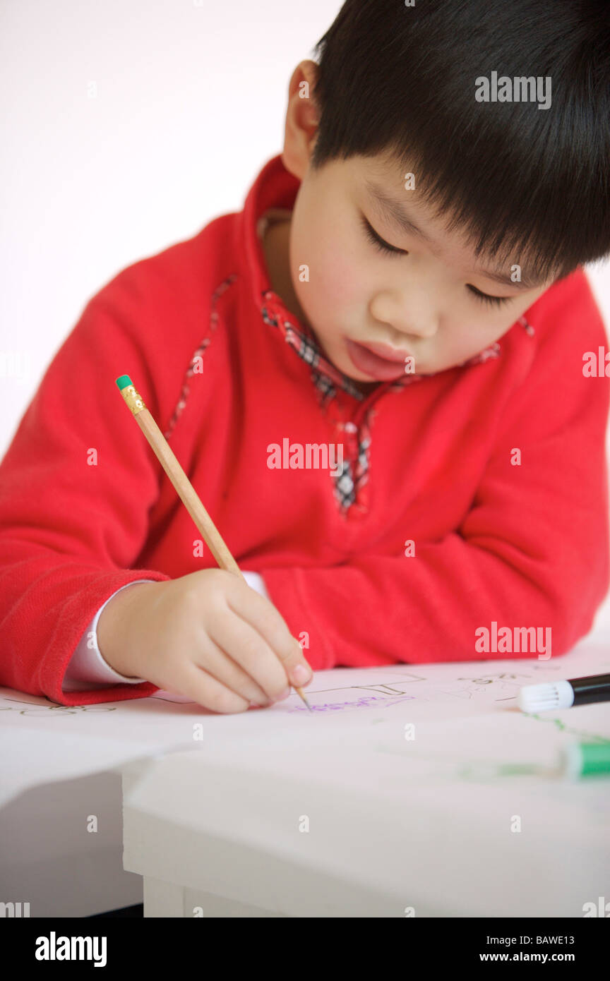 Boy drawing on paper with pencil Stock Photo - Alamy