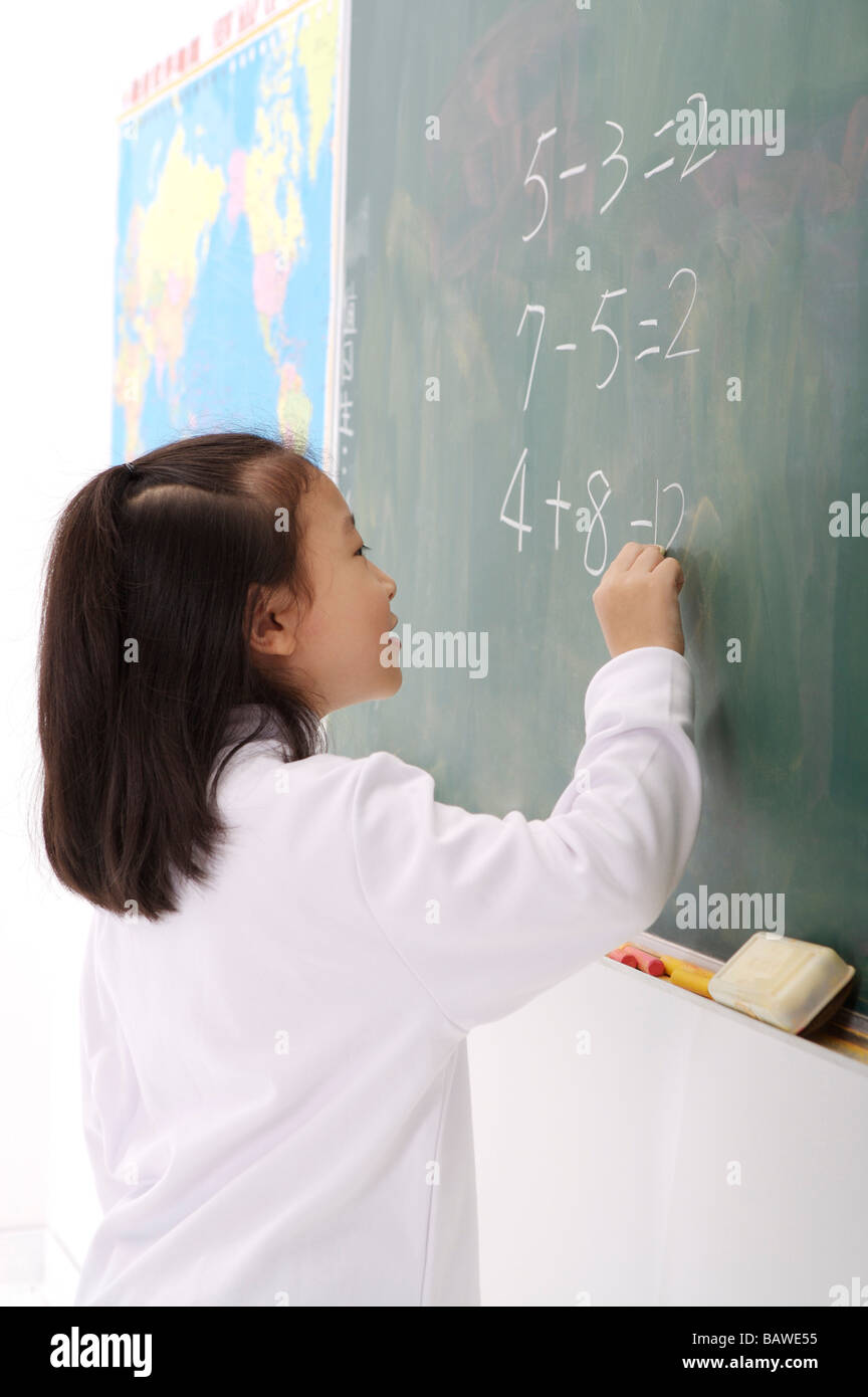 Girl solving mathematical equation on blackboard side view Stock Photo ...