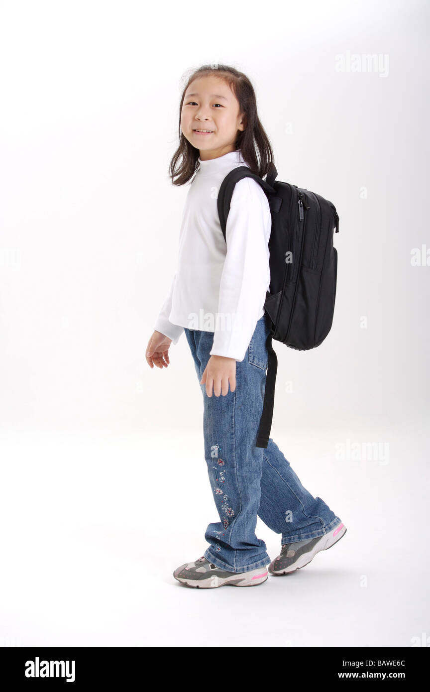 Girl walking with backpack on her back Stock Photo - Alamy