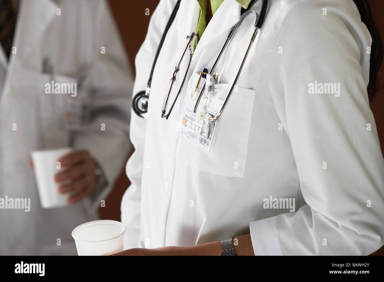 Close up of female doctor holding plastic cup Stock Photo - Alamy