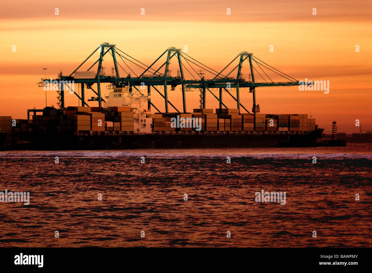 Cargo ship at sunset Stock Photo - Alamy