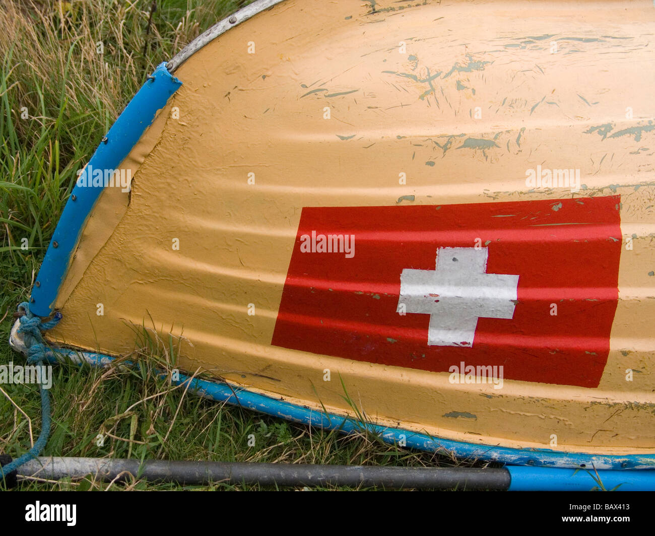 Beached rowing boat with the Swiss national flag painted on the bow ...