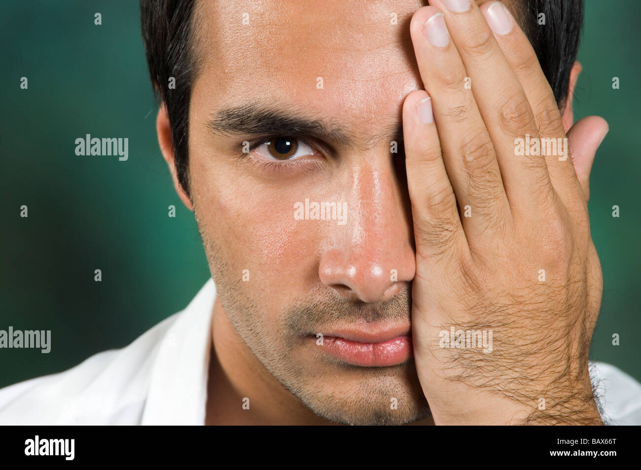 Young man hand over eye Stock Photo - Alamy