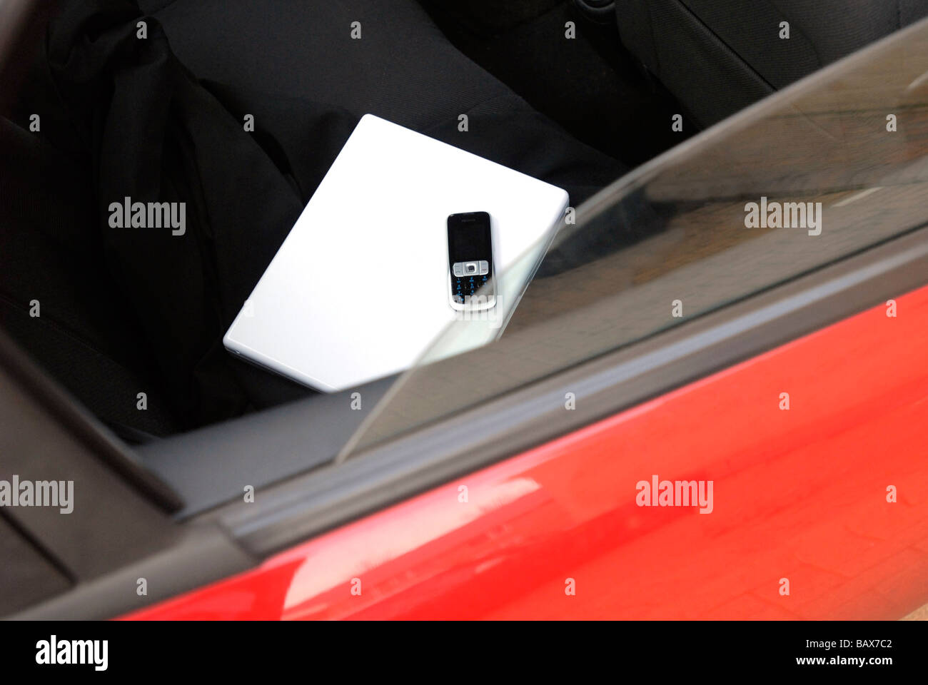 Laptop and phone on show in the back of a car Stock Photo - Alamy