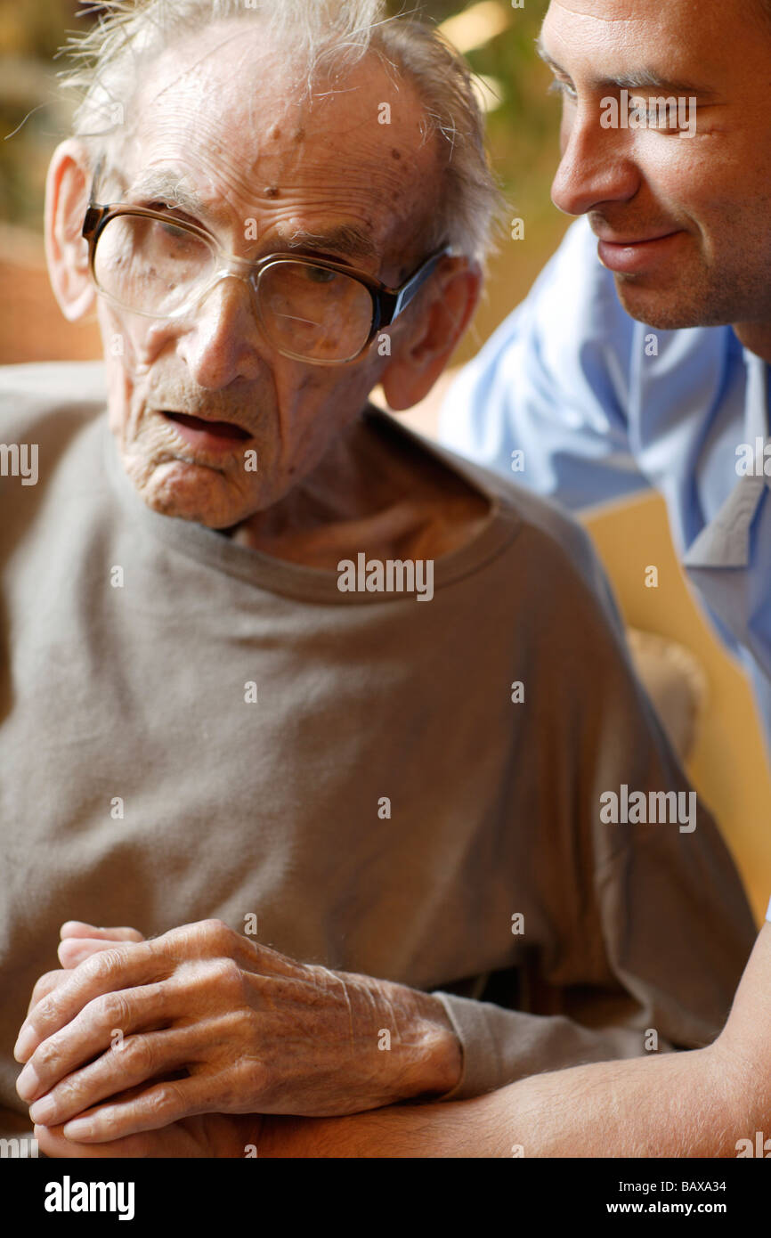 Nursing home elderly man with a man nurse Stock Photo - Alamy