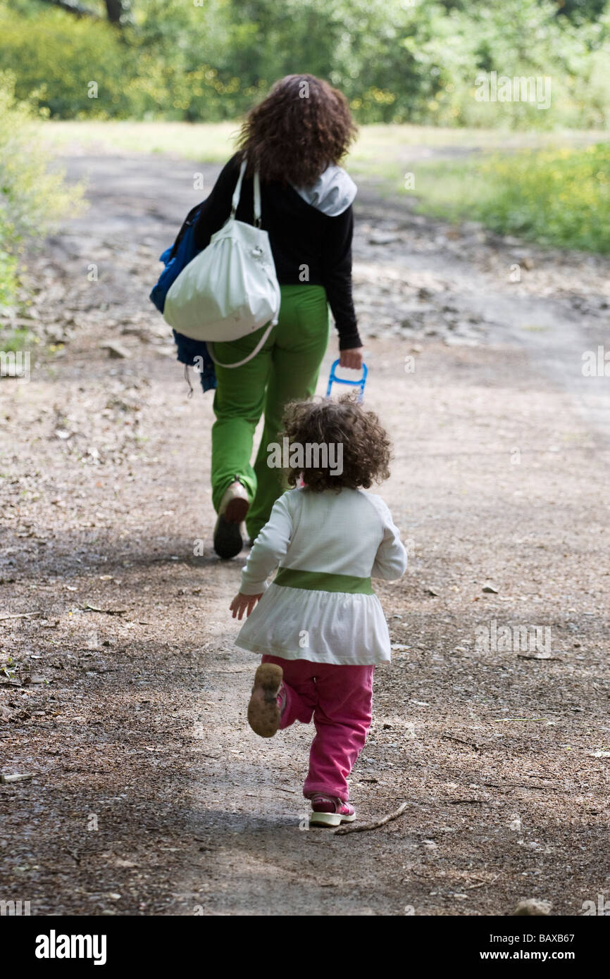a kid is following her mother by running Stock Photo - Alamy