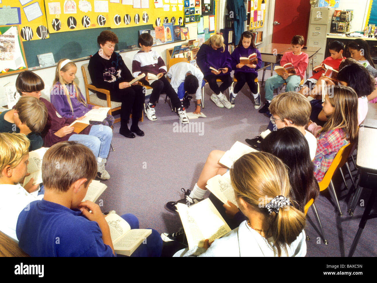 Student teacher read group class Stock Photo - Alamy