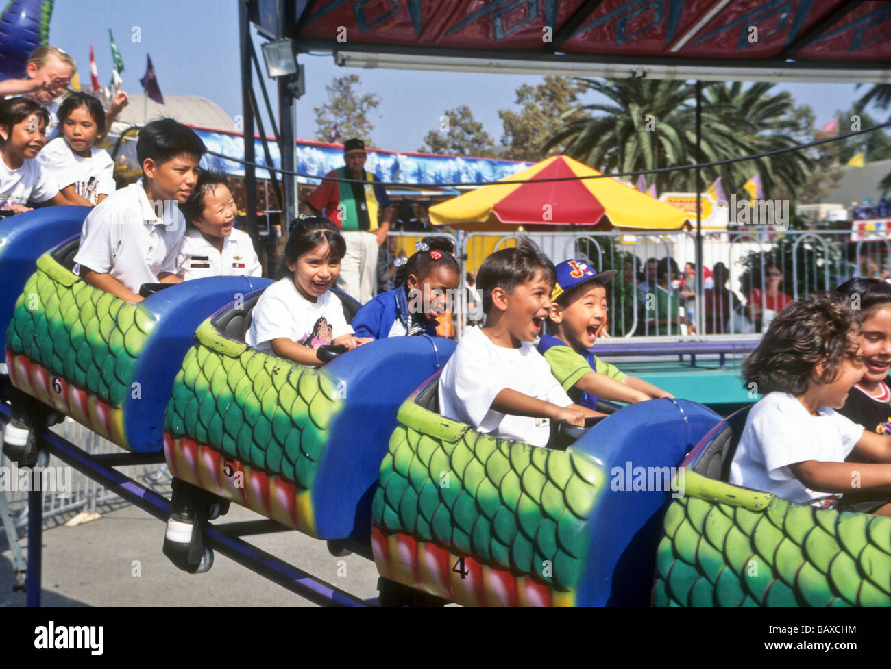 Children ride carnival dragon roller coaster thrill fun excite laugh ...