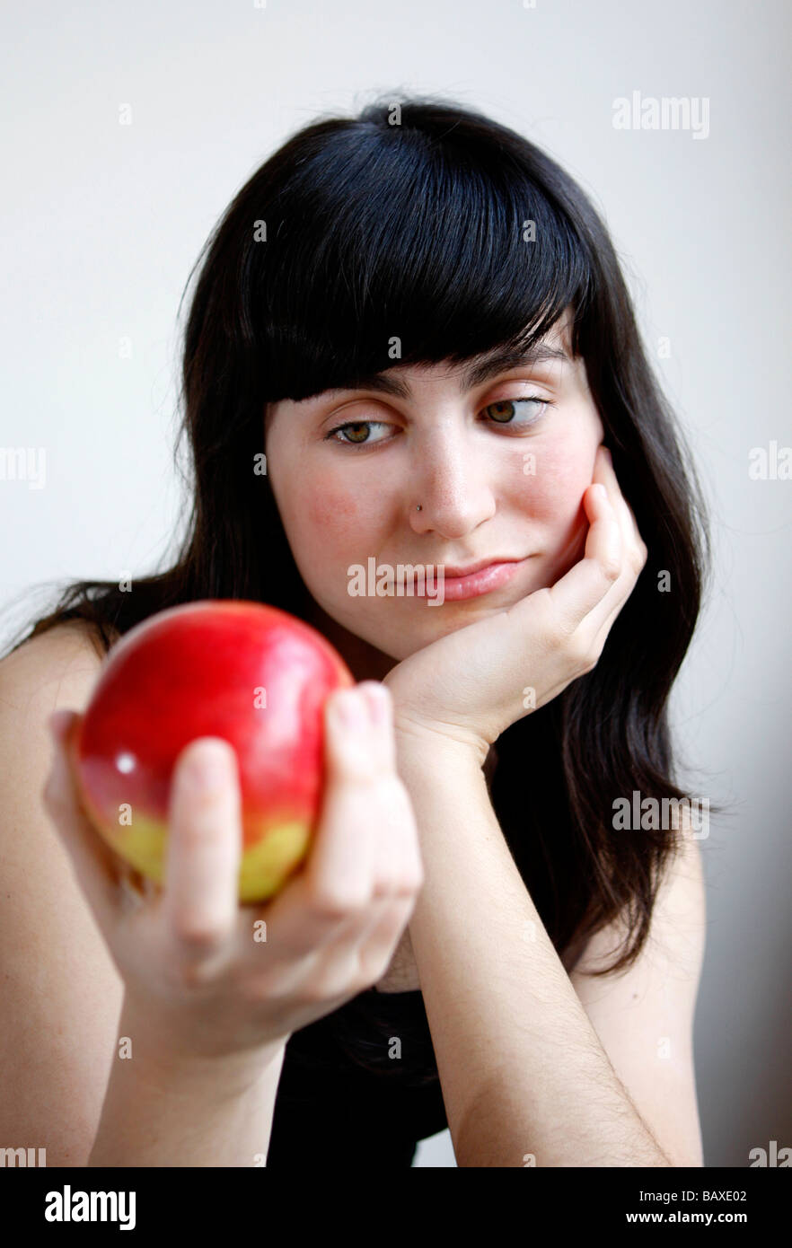 A woman looking bored at an apple Stock Photo - Alamy