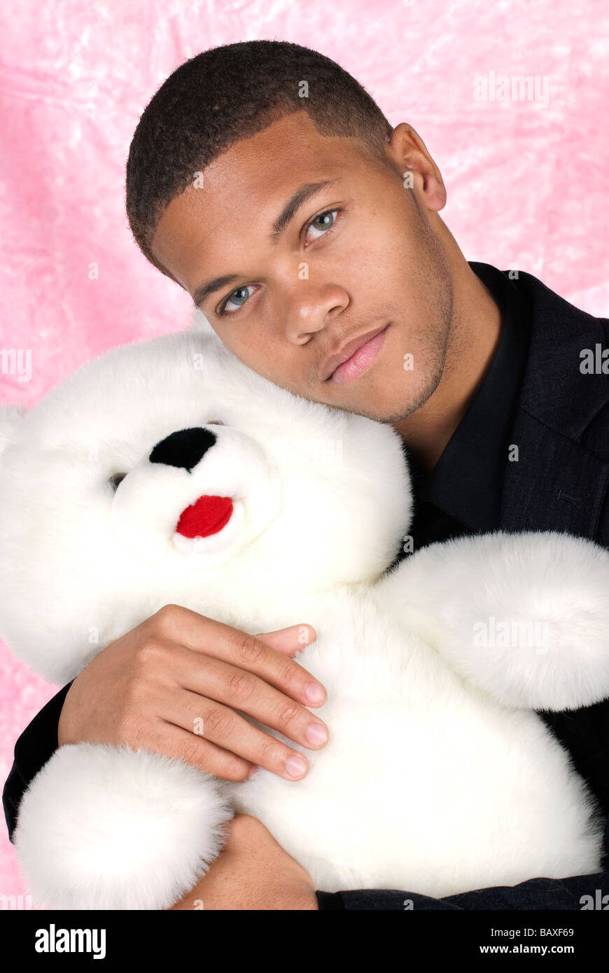 African American man cuddles with his large white teddy bear during ...