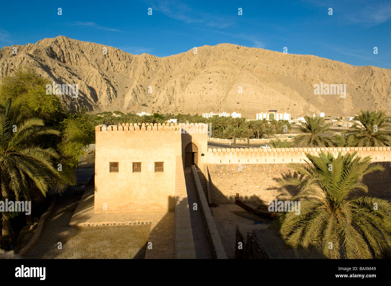Fortress and palm trees in a mountain landscape, Hajjar mountains ...