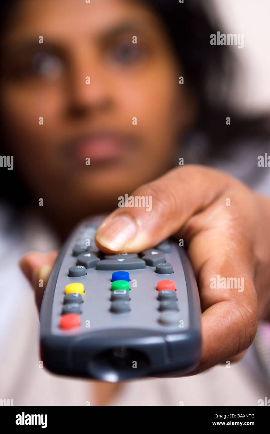 Woman with TV remote Stock Photo - Alamy