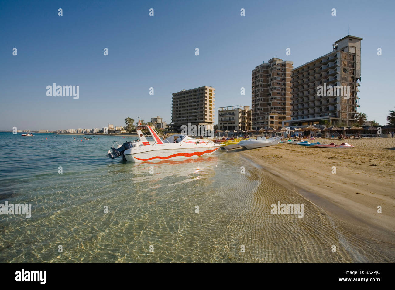 Boats on Varosha Beach with ruins of abandoned hotels in the background ...