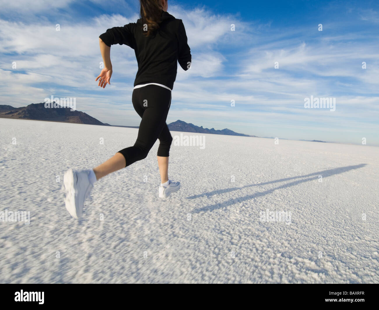 Hispanic woman jogging on salt flats Stock Photo - Alamy