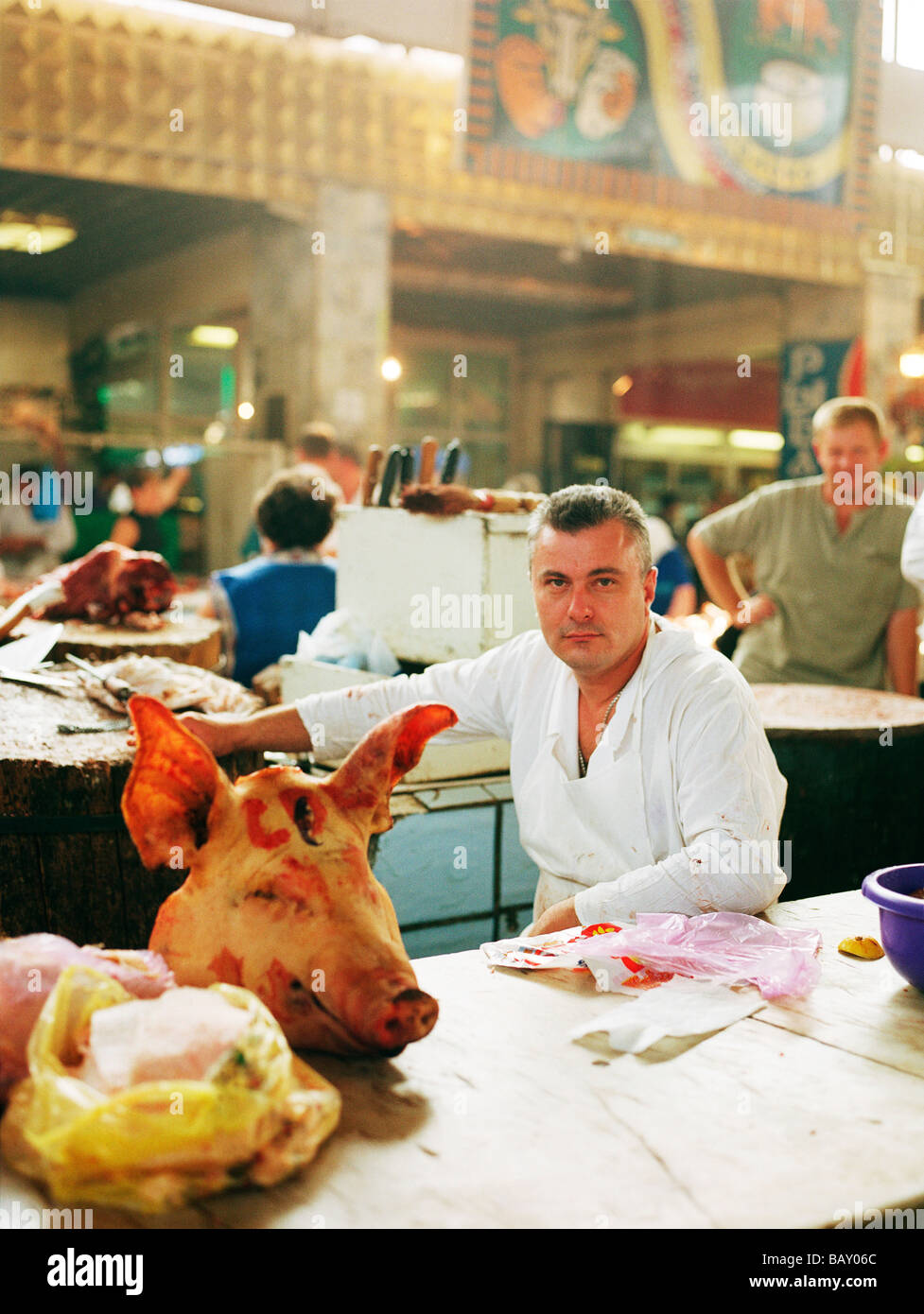 Butcher presenting pig's head at market hall, Cheryomushkinsky, Moscow ...