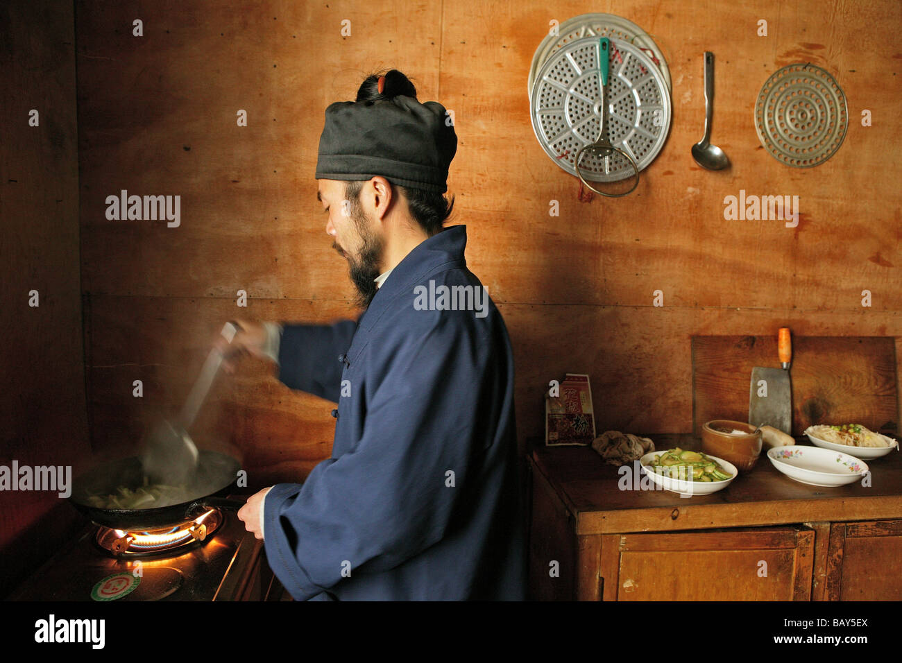 A monk cooking in the kitchen of the monastery Cui Yun Gong, Hua Shan ...