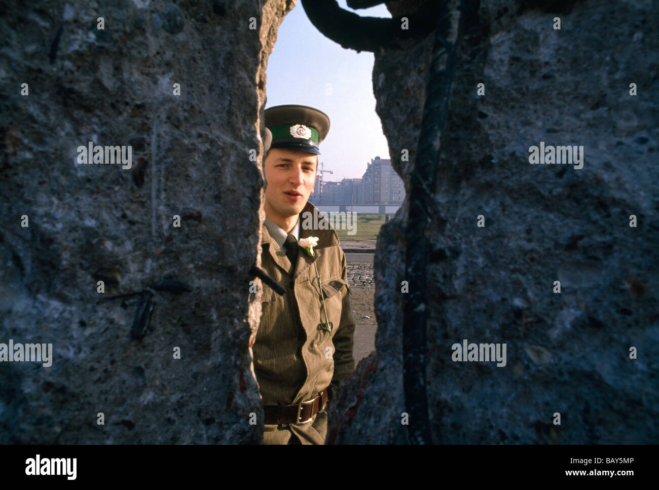 Berlin Wall, 1990, at Potsdamer Platz, East German border guard looking ...
